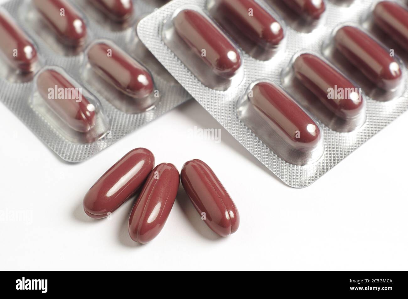Medical capsules closeup. Pile of brown tablets on white background ...