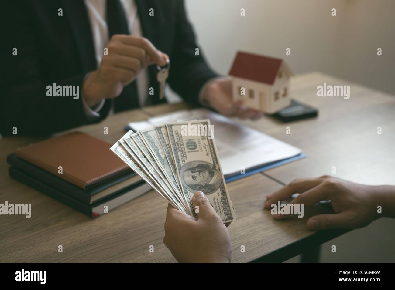 Businessman handed the house model and new homeowner giving money to ...