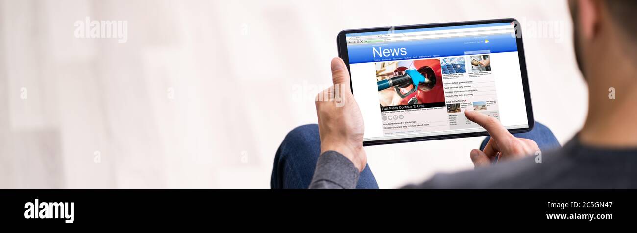 Reading Newspaper Article Online On Digital Tablet Stock Photo - Alamy