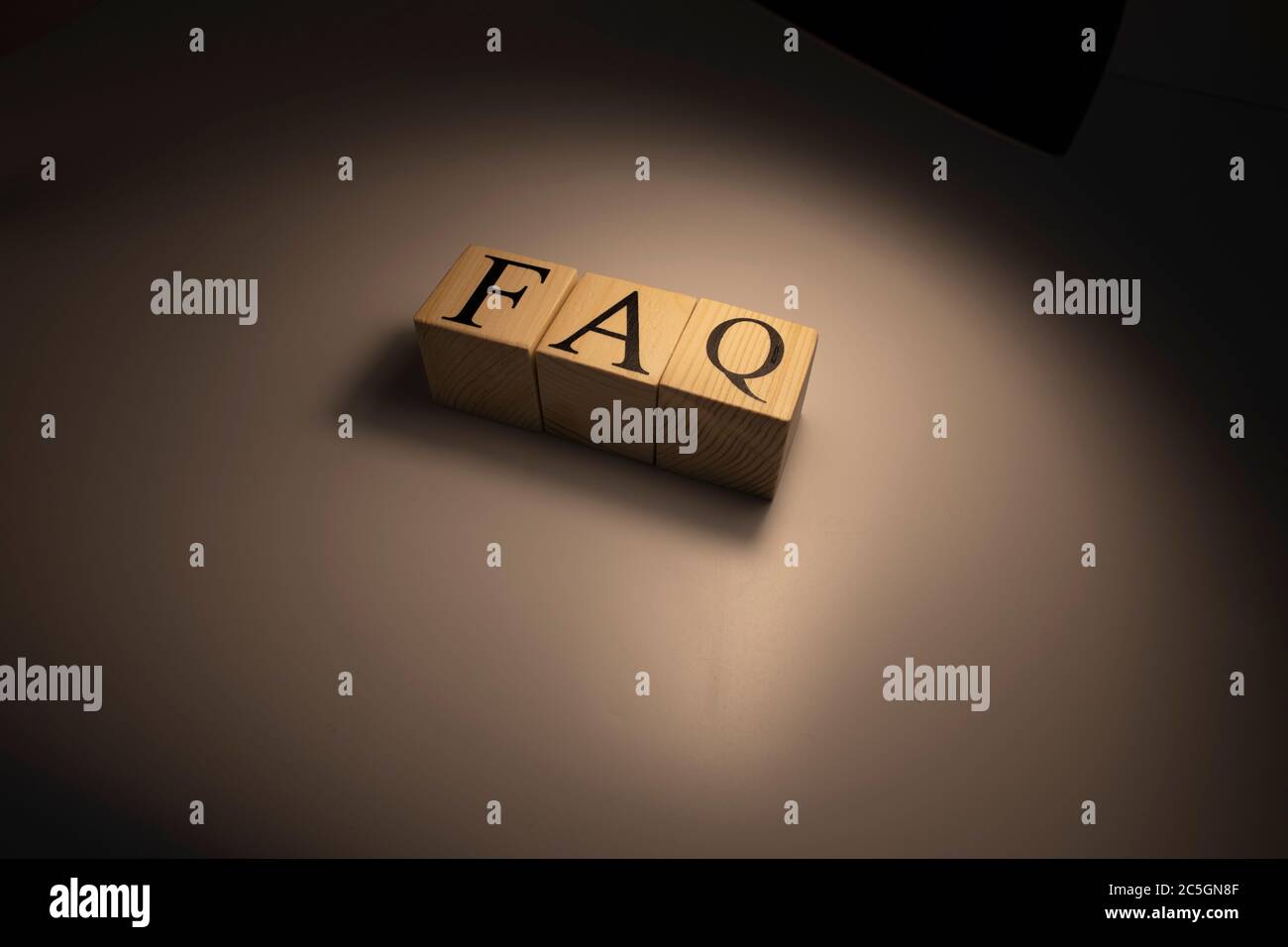FAQ word from wooden cubes. Spot light and white background. Close up ...