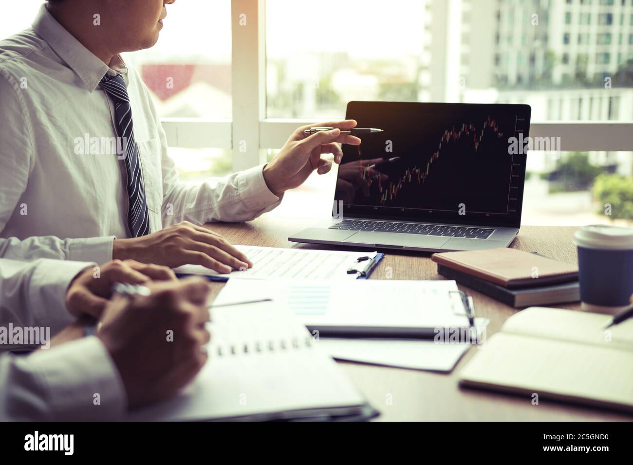 Businessman point to the laptop looking graph of the company financial ...