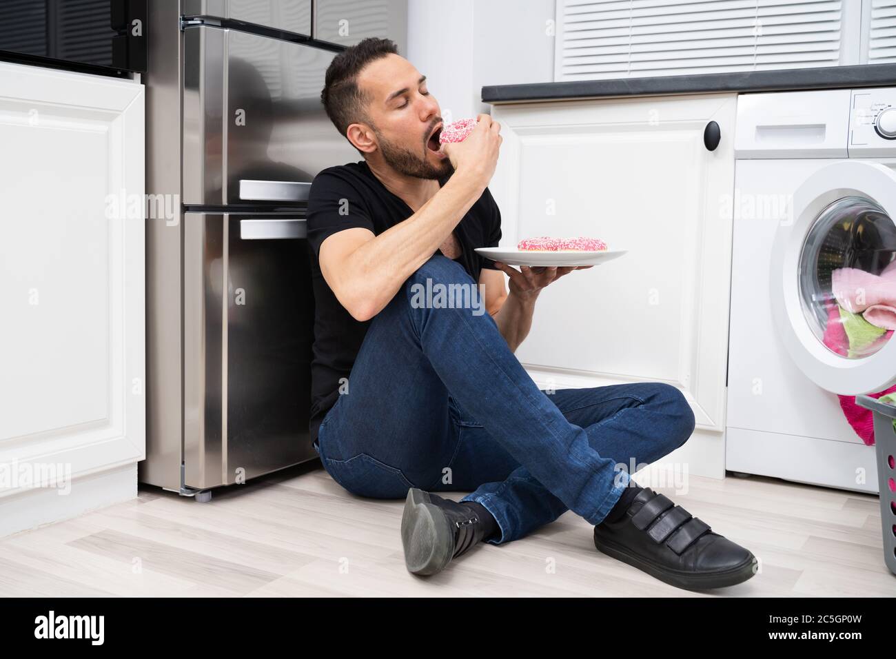 Sweet Indulgence Eating At Night Near Refrigerator Stock Photo - Alamy