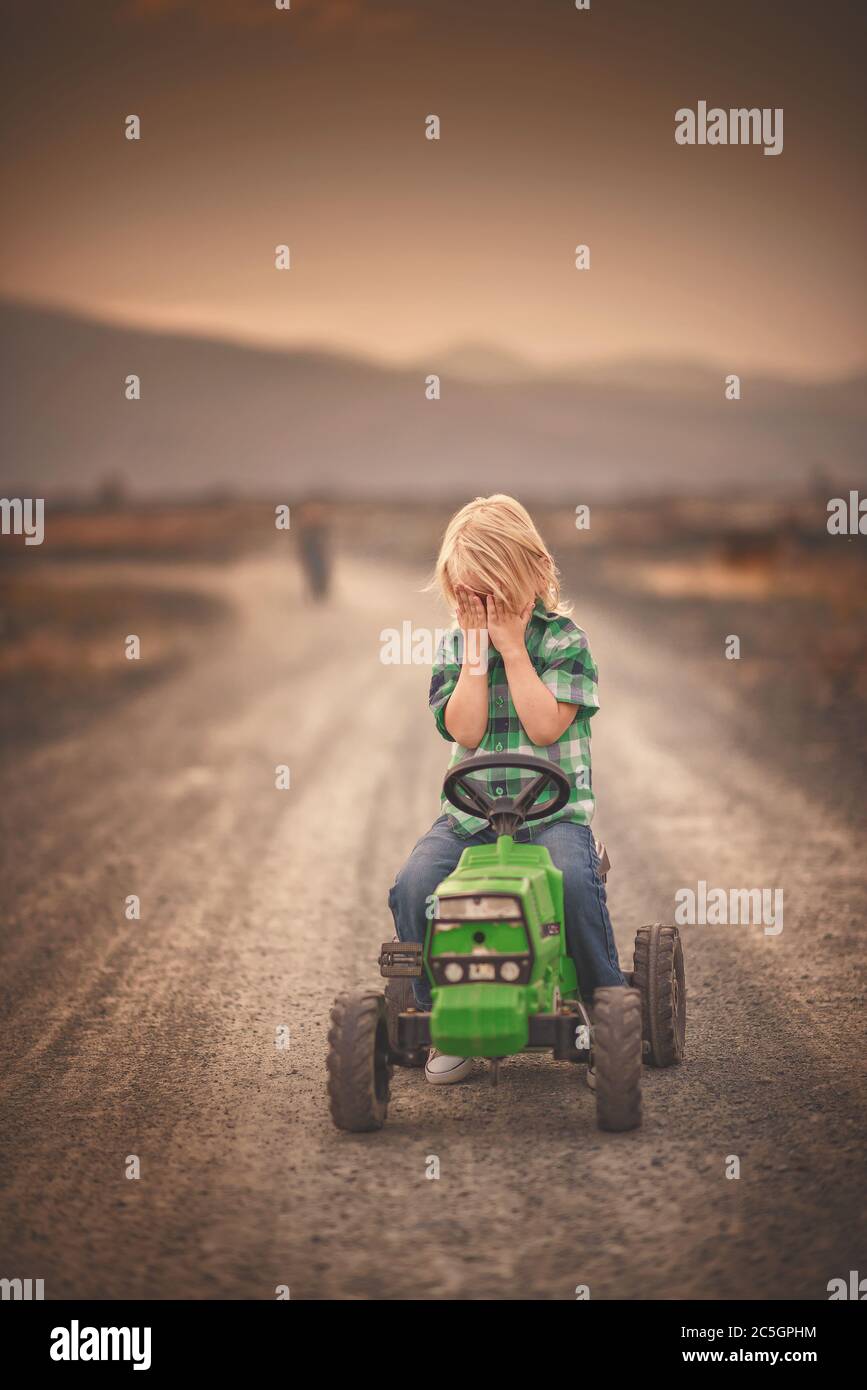 boy driving toy tractor concept of a happy childhood Stock Photo - Alamy