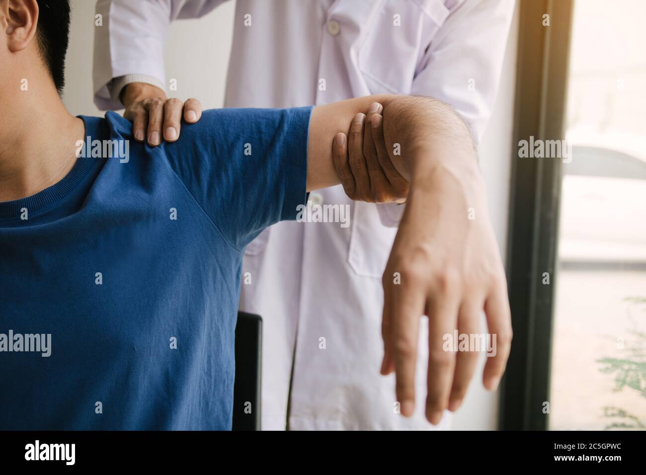 Physical therapists press to the patient shoulder check for pain Stock ...