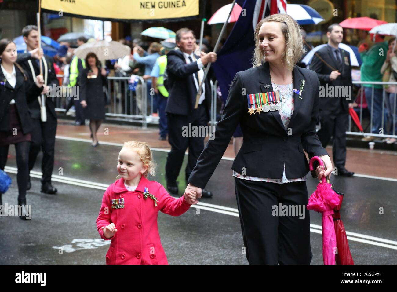 A little girl waves to the crowds as she takes part in the annual ANZAC ...