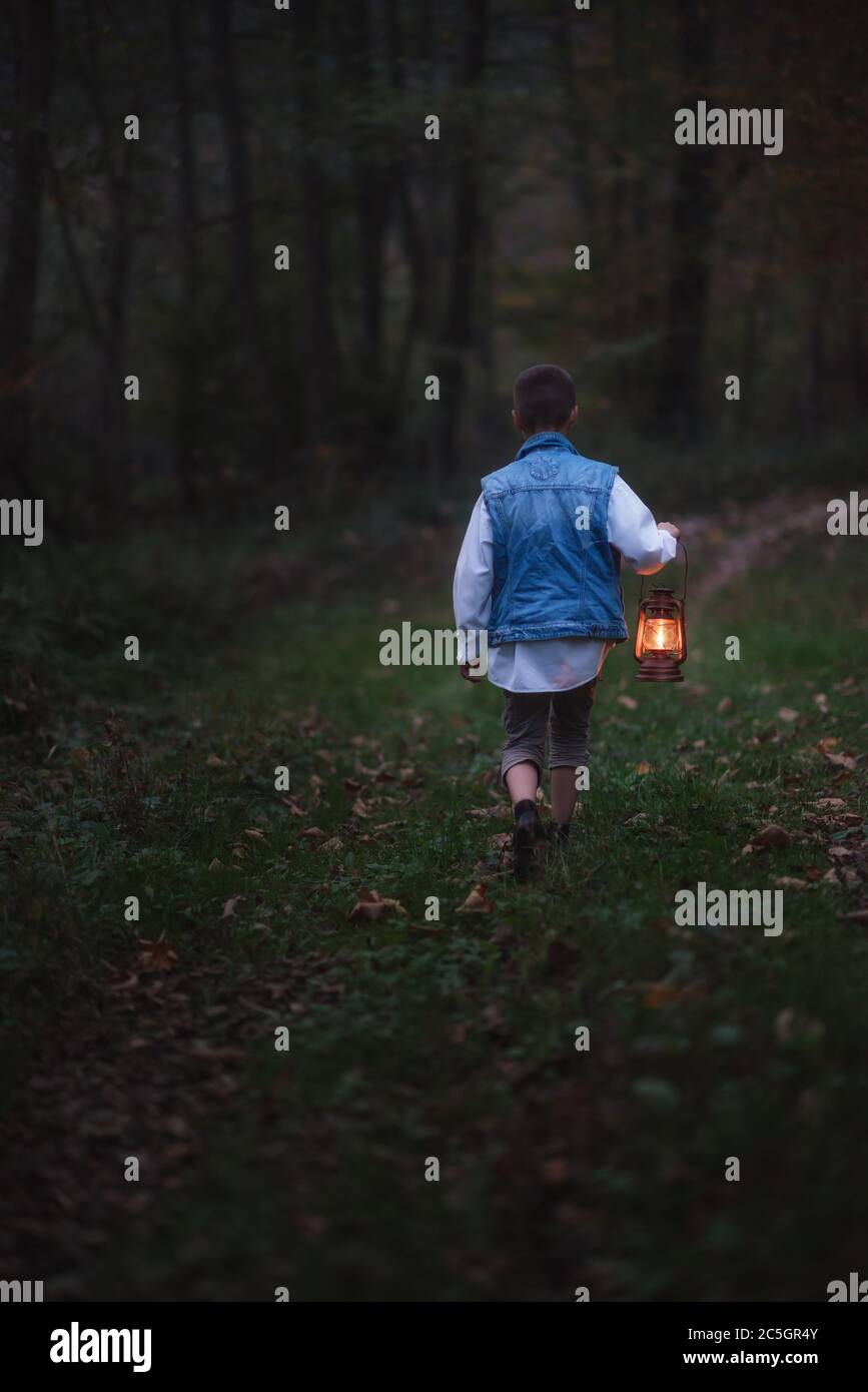 Lost child holding an old lamp in an apocalyptic environment Stock ...