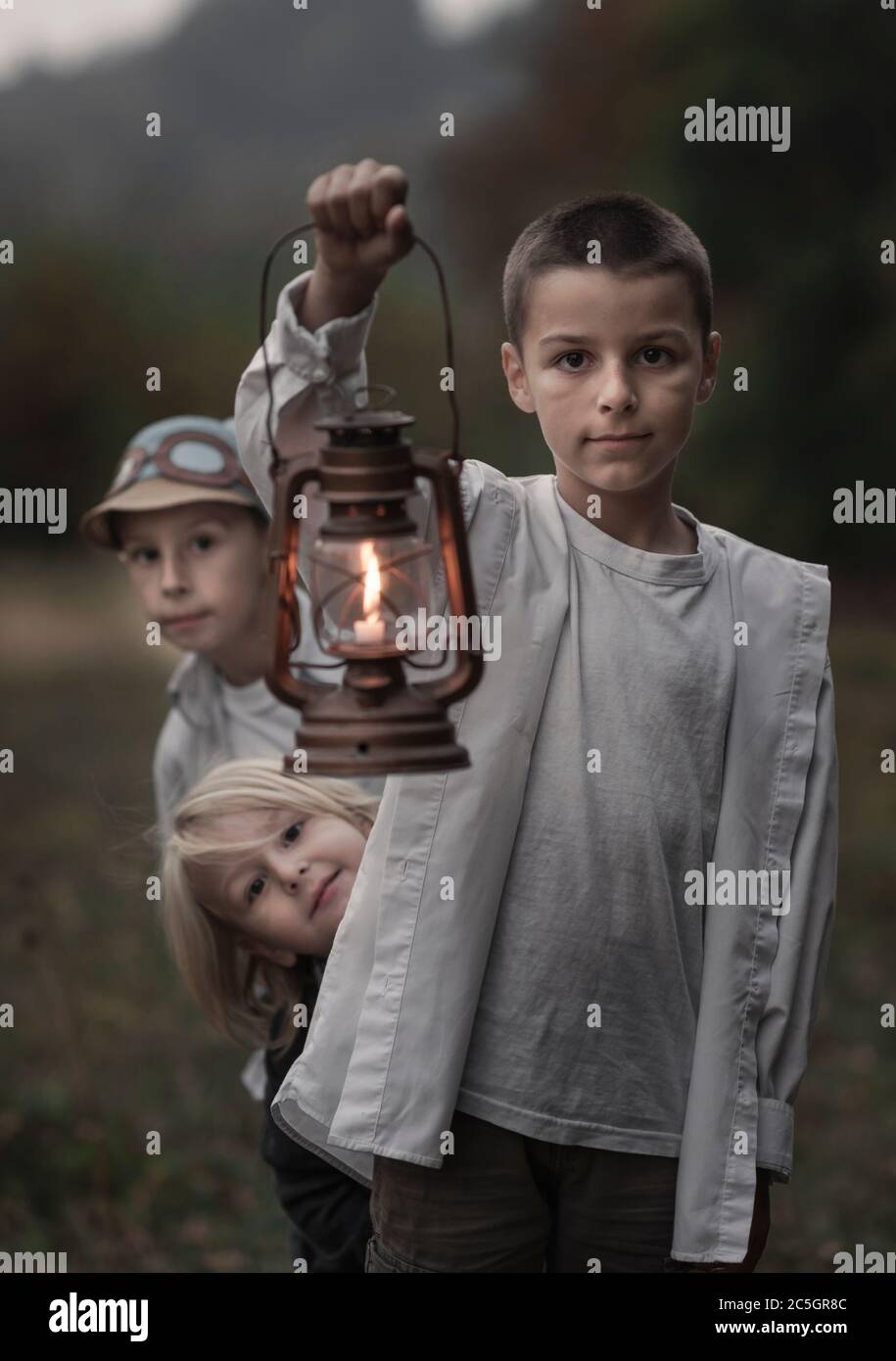 children playing with an old lamp in the forest Stock Photo - Alamy