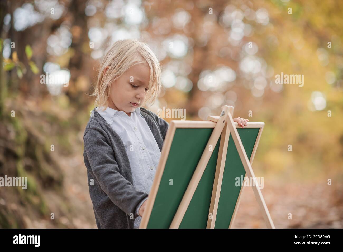 boy writes on a chalkboard outside Stock Photo - Alamy