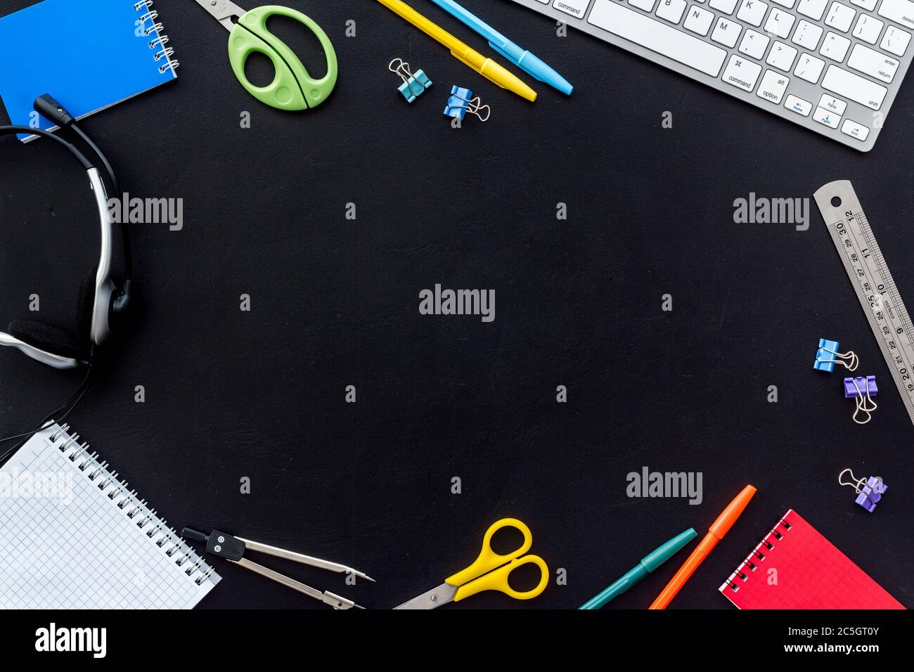 E-learning. Stationery, headphones and keyboard on black table top-down ...