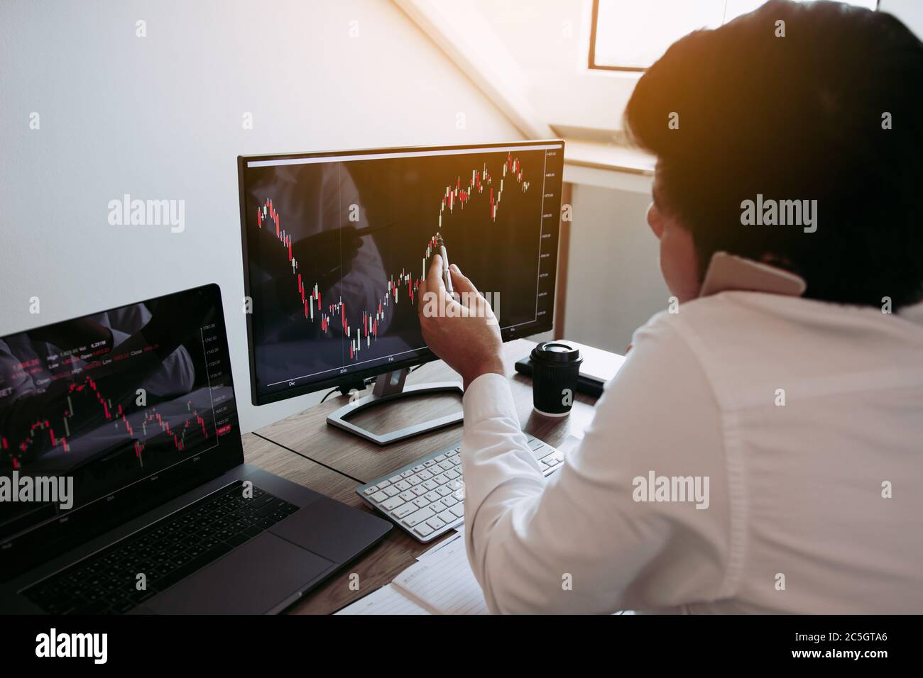 Agent trader man talking at telephone and checking business stock data ...
