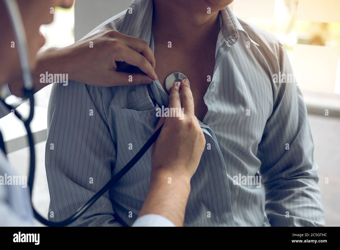 Asian doctor is using a stethoscope listen to the heartbeat of the ...