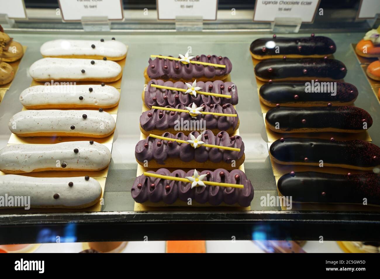 Assorted flavor colorful eclair and French pastry bakery displayed in ...