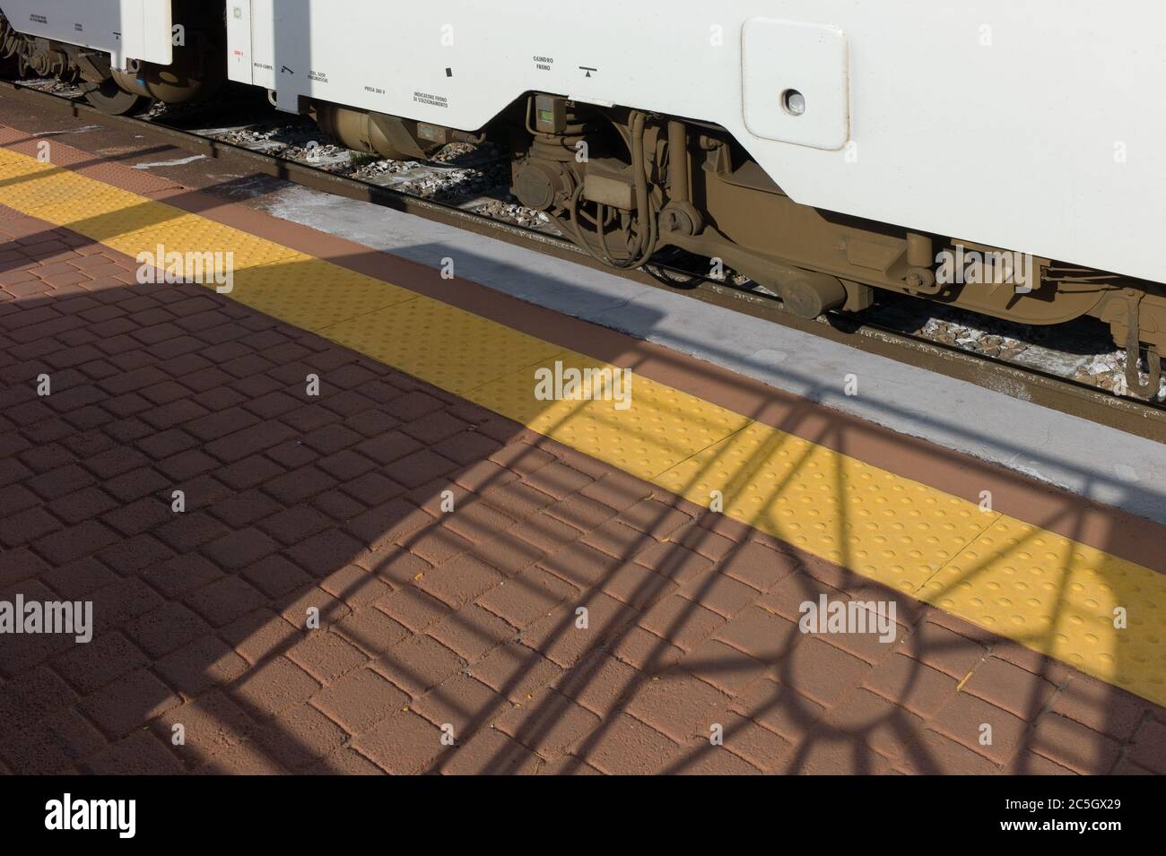 Platform at a train station in Padua with yellow stripes stay behind ...