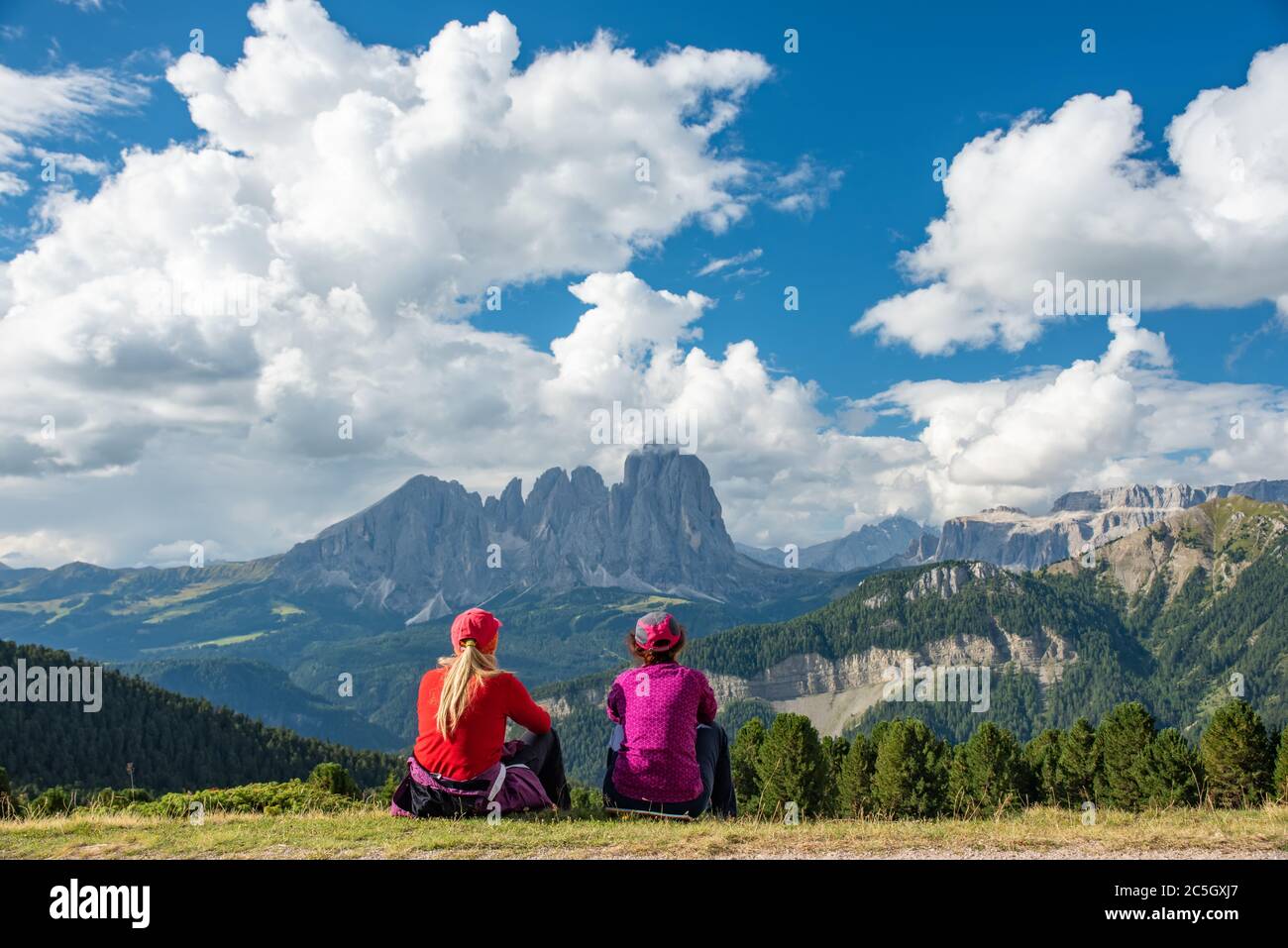 Sporty Young woman friends on mountain trail Dolomites Mountains, Italy ...