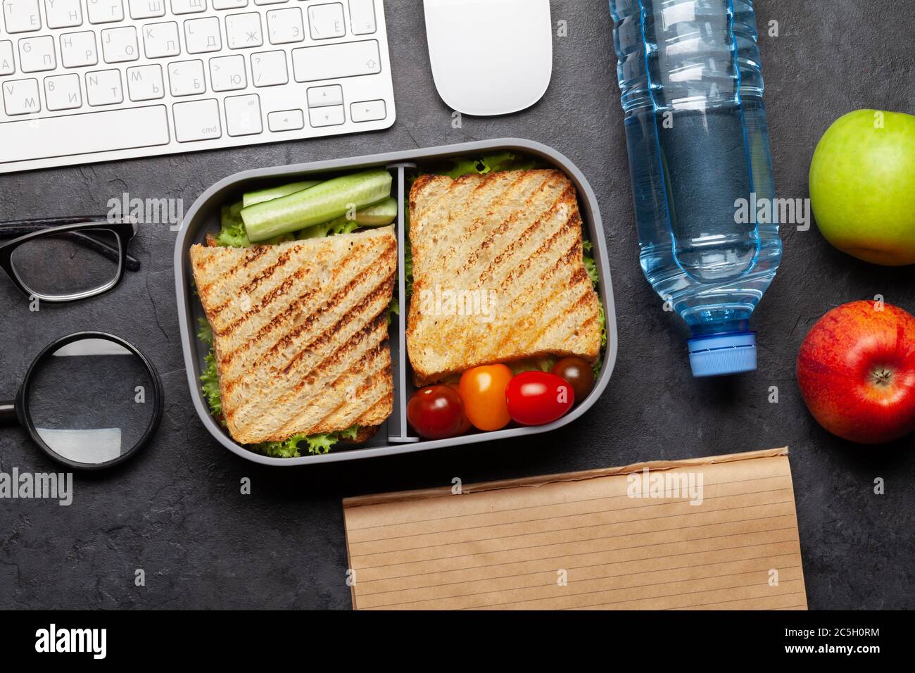 Healthy lunch box with sandwich and vegetables on office table. Top ...