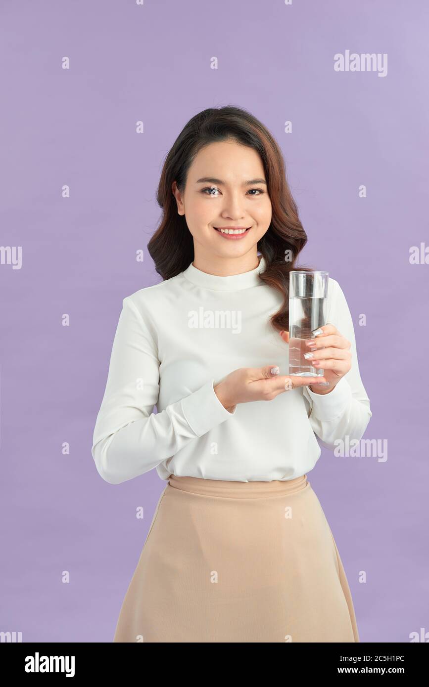Young smiling woman holding water glass Stock Photo - Alamy