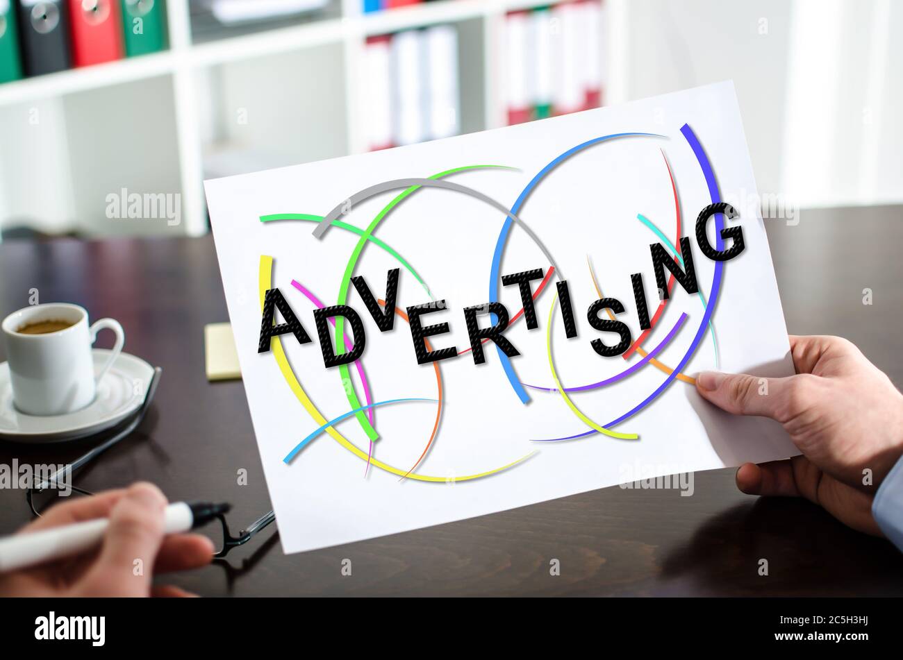 Hand holding a paper showing advertising concept Stock Photo - Alamy