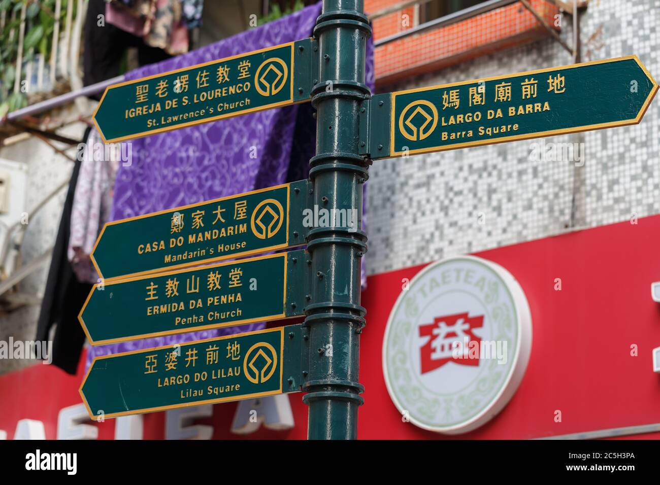 Signpost with green arrows showing the way to several macanese ...