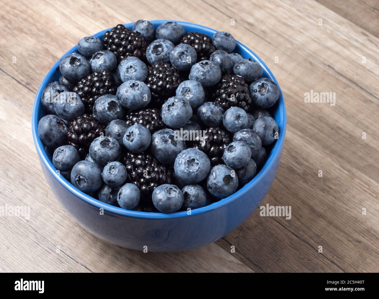 Forest berries (blueberry,bramble) in a ceramic blue bowl Stock Photo ...