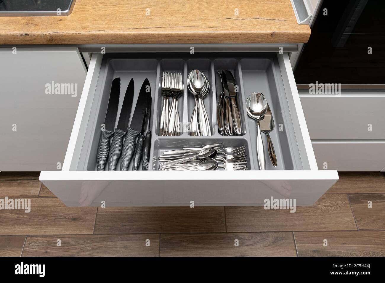 Stainless steel cutlery set in drawer. Opened kitchen drawer Stock ...