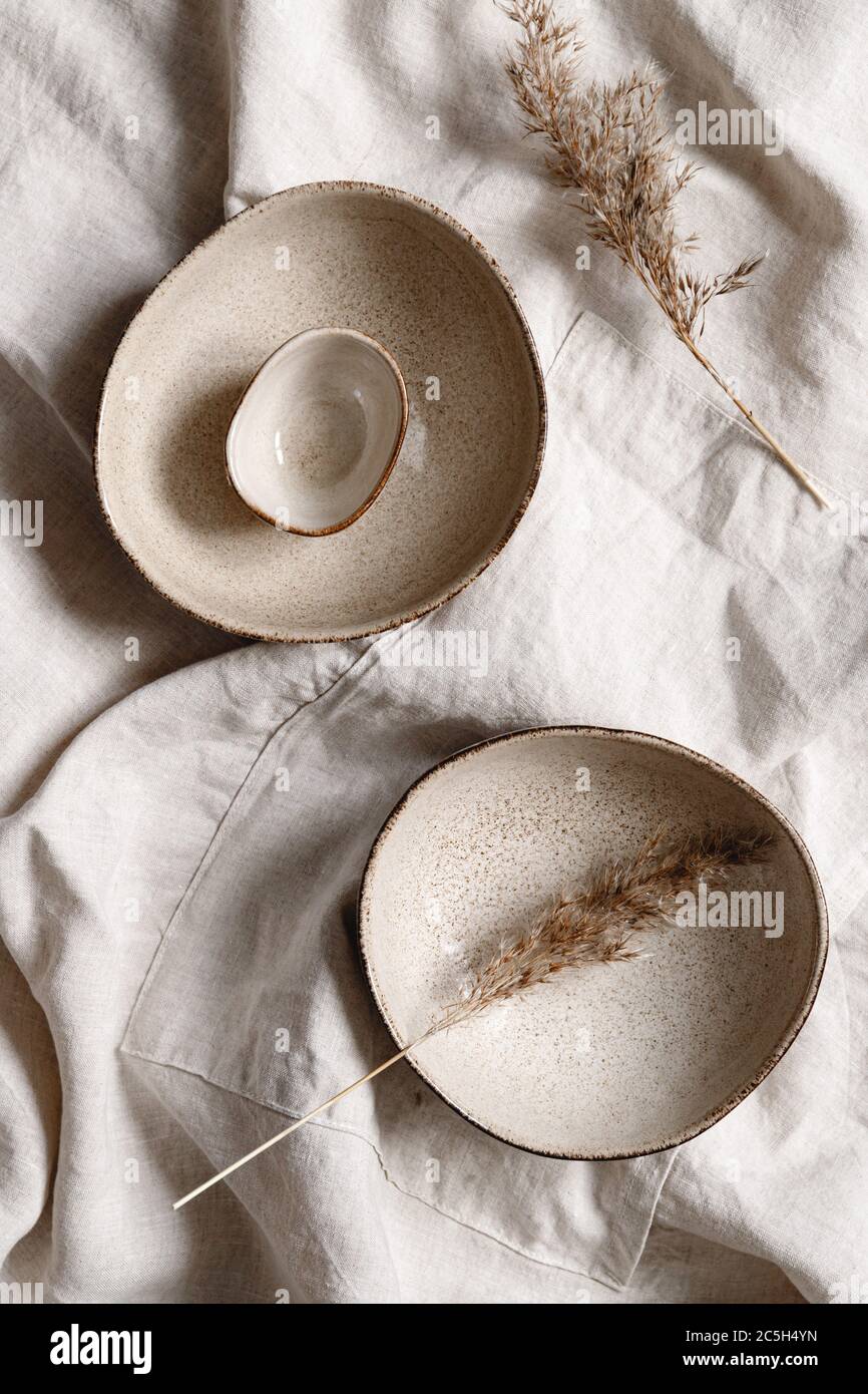 Modern minimalist ceramics set over a linen cloth. Natural products or food concept, top view ...