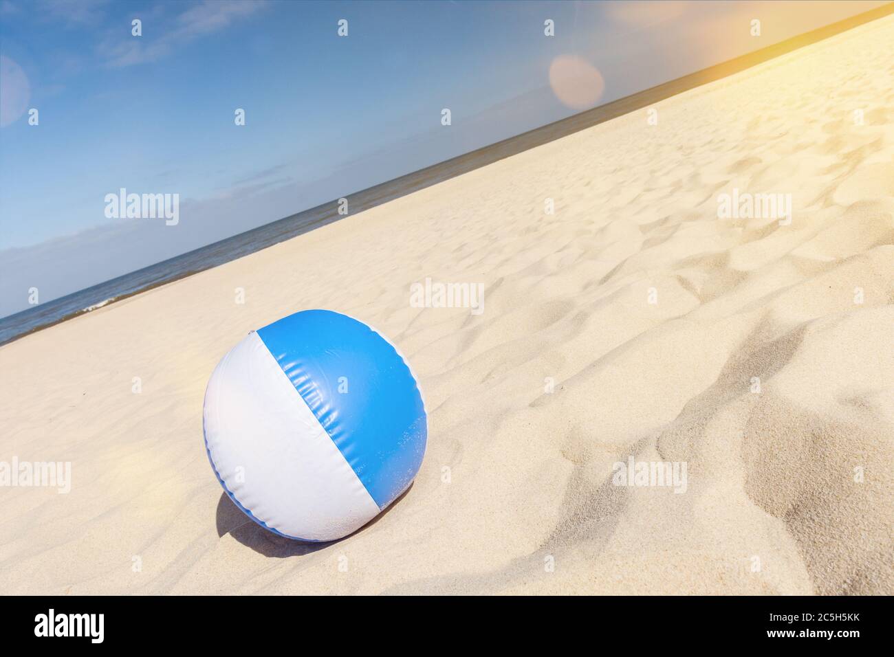 Beach ball on a beautiful beach in summer with scenic lens flare and ...