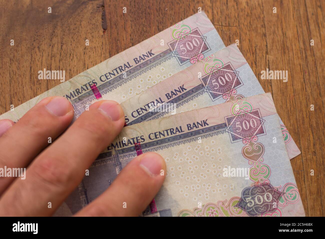 Persons hand giving the Currency of the United Arab Emirates (UAE) on ...