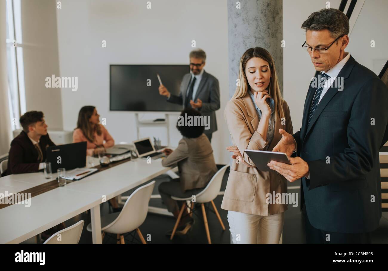 Creative executives using digital tablet in the office Stock Photo - Alamy