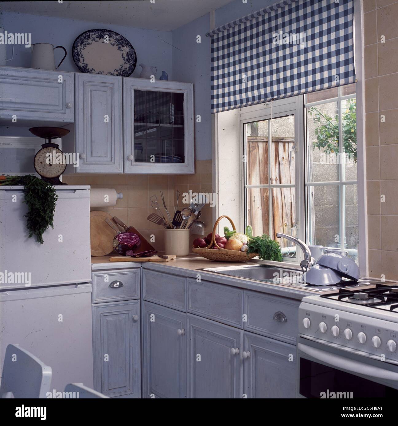 Blue and white check blind in small family kitchen Stock Photo - Alamy