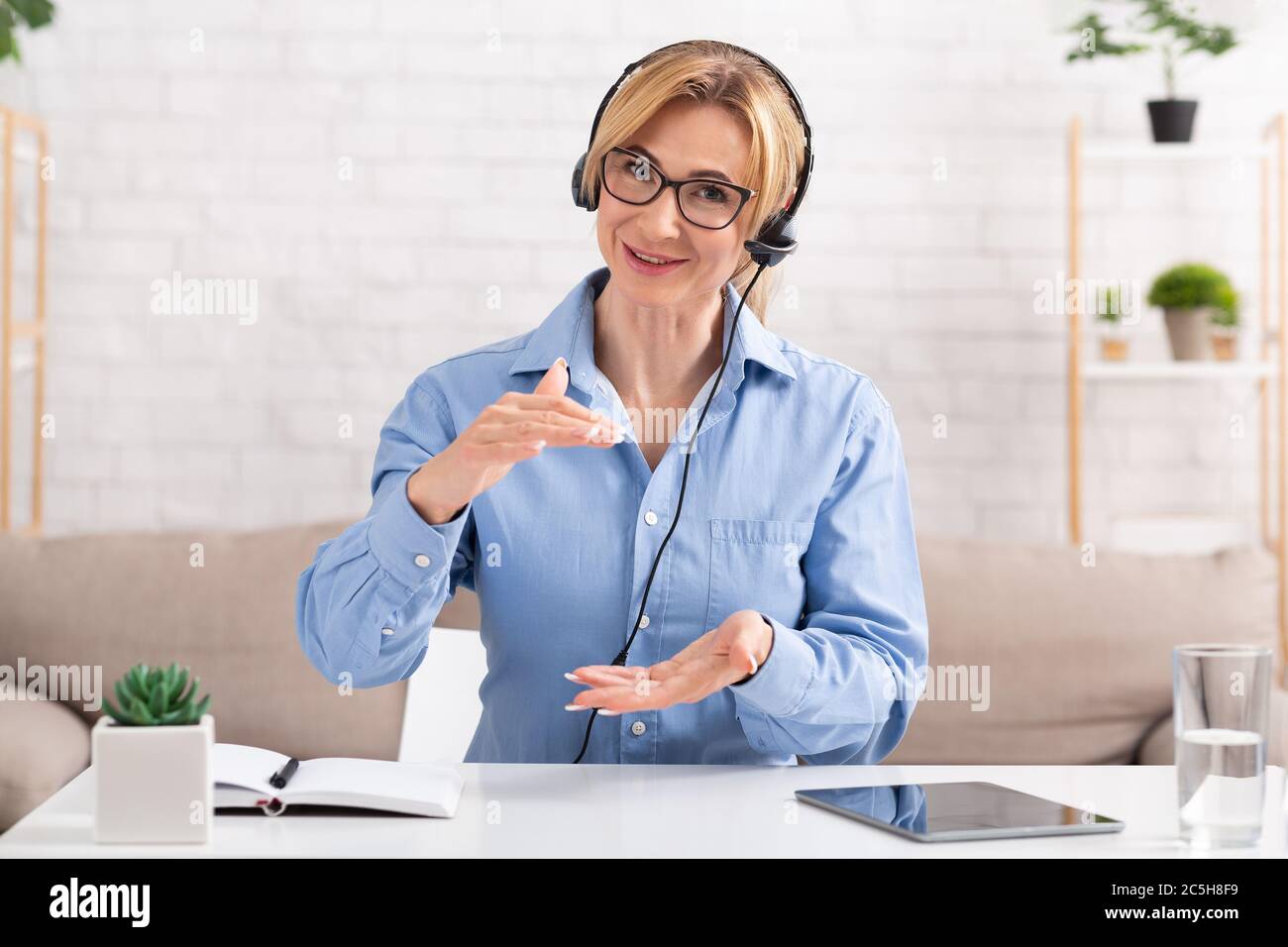 Modern remote work. Friendly woman with headset explains to client ...