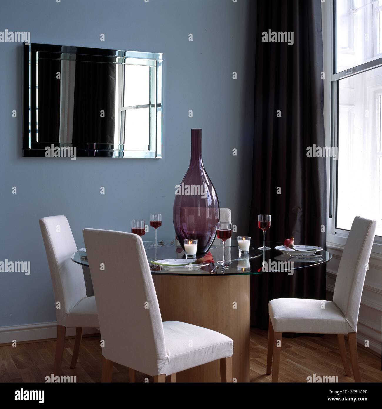 Modern interior showing diningroom with round table set for meal Stock ...