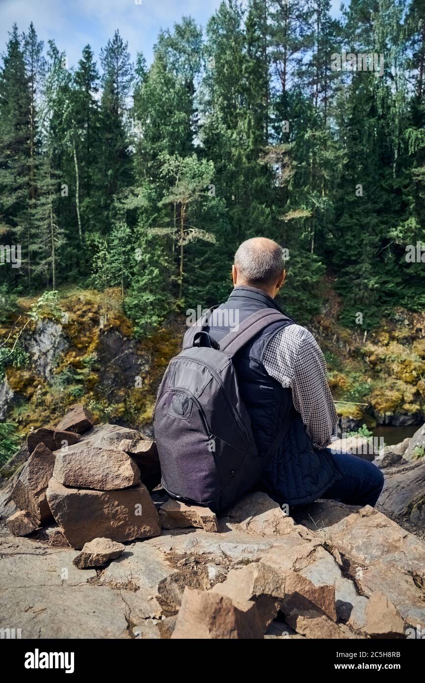 Back view man sitting on rocks hi-res stock photography and images - Alamy