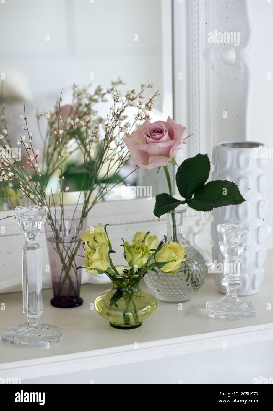 White mantlepiece in front of mirror with pink rose and yellow roses in ...