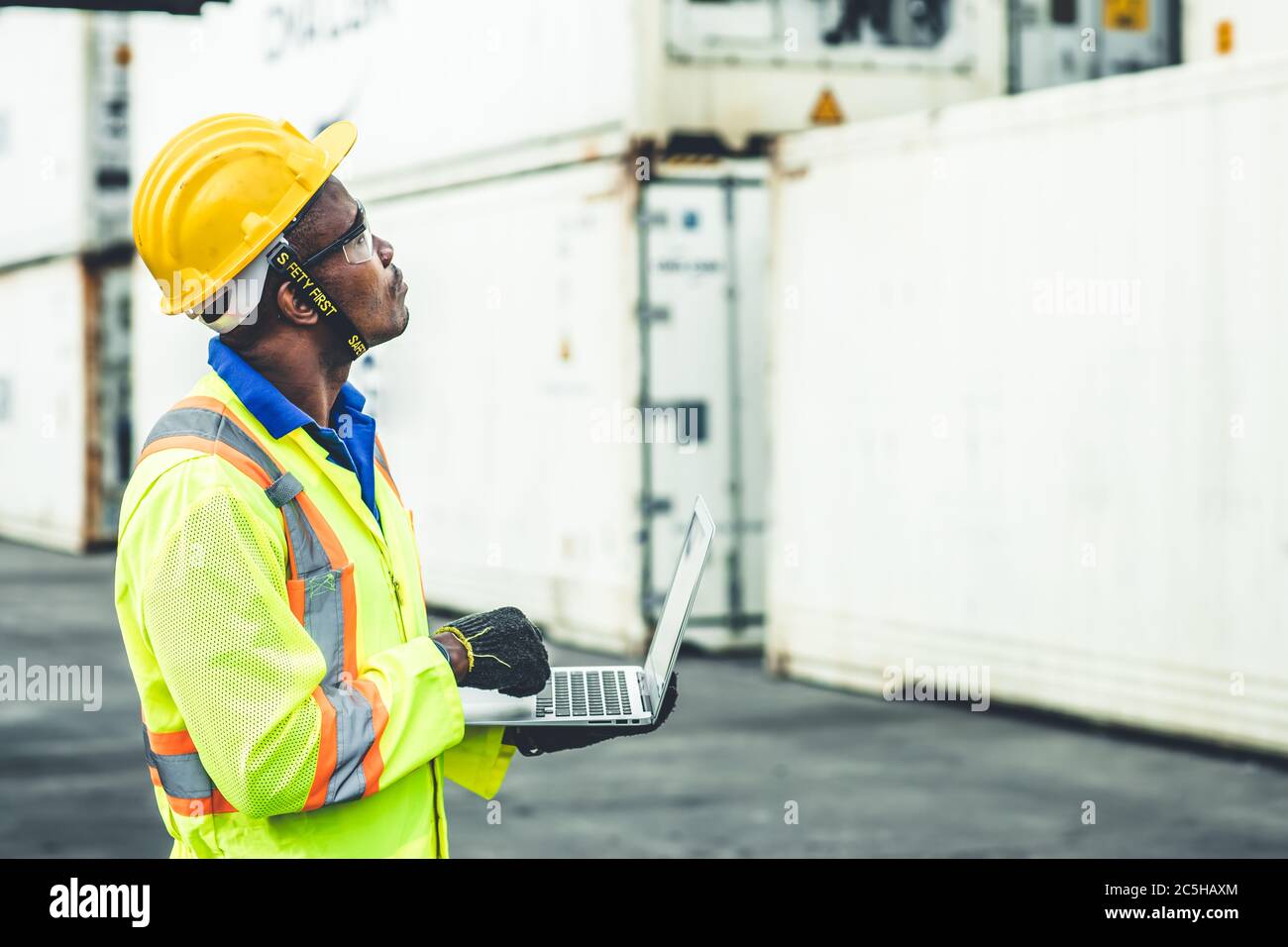 Black African worker working in logistic shipping using laptop to ...