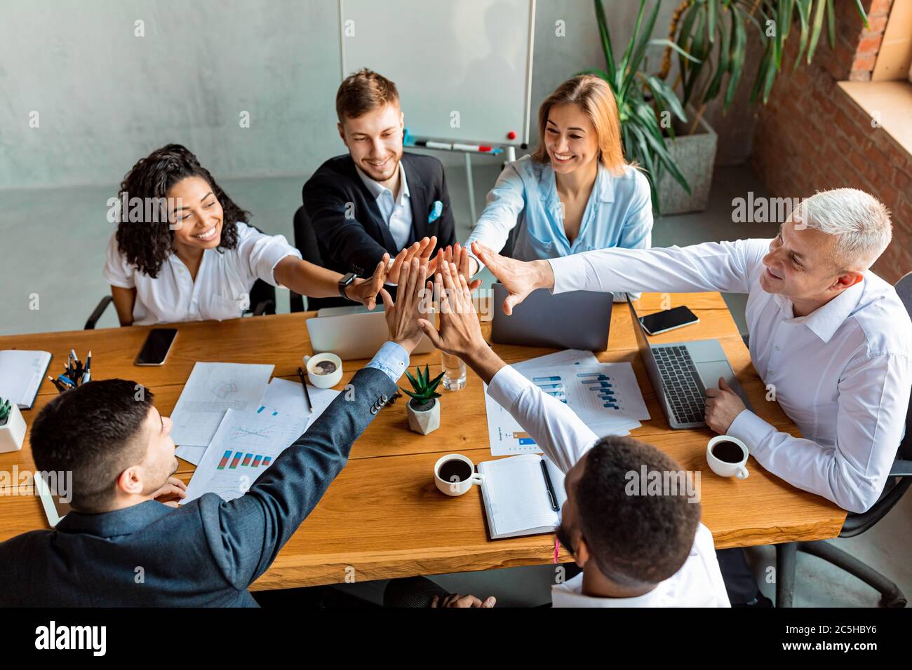 Business Team Giving High-Five Celebrating Success At Work In Office ...