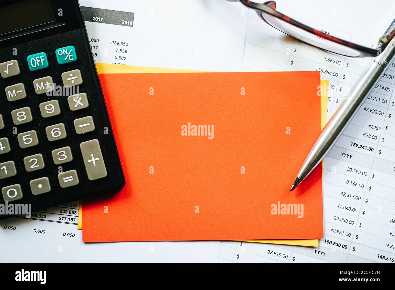 Financial budget report paper with a calculator, pen, glass and red ...