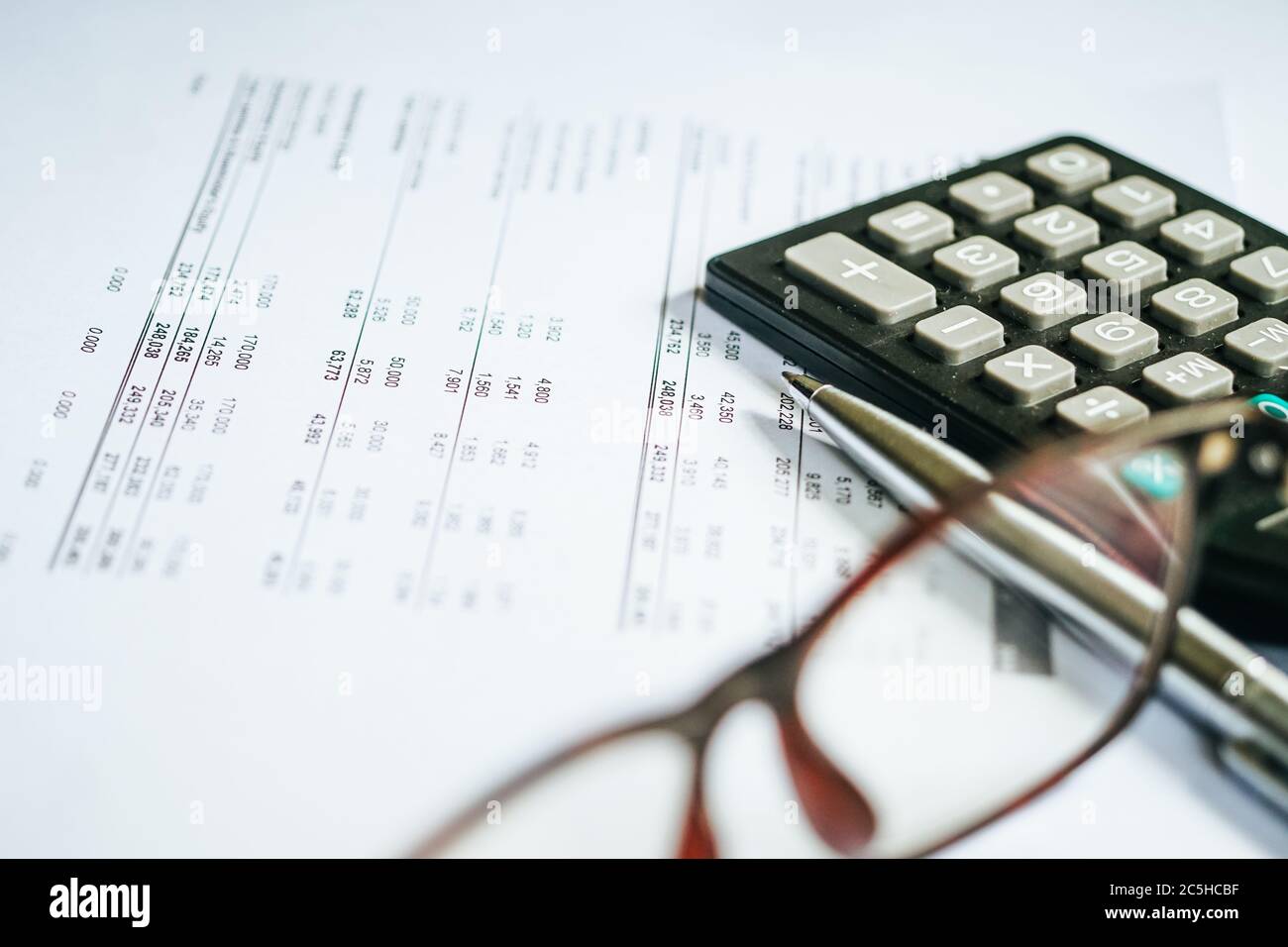 Financial calculation numbers chart with pen, calculator, glass and ...