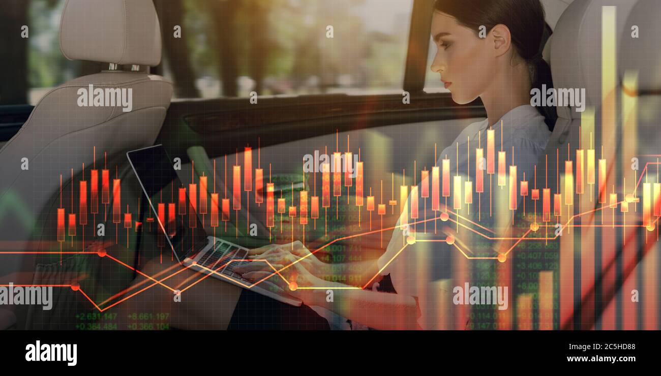 Business lady researching stock market on laptop in her car salon ...