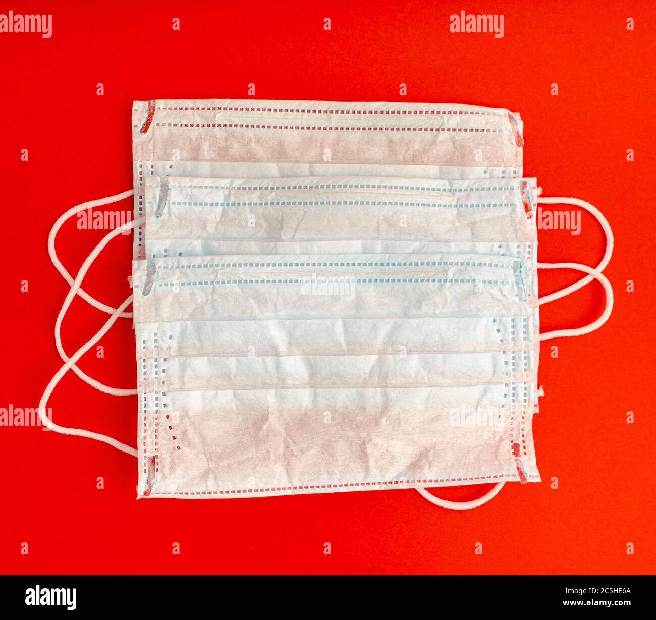 Set of three White medical masks. Medical protective masks over red ...