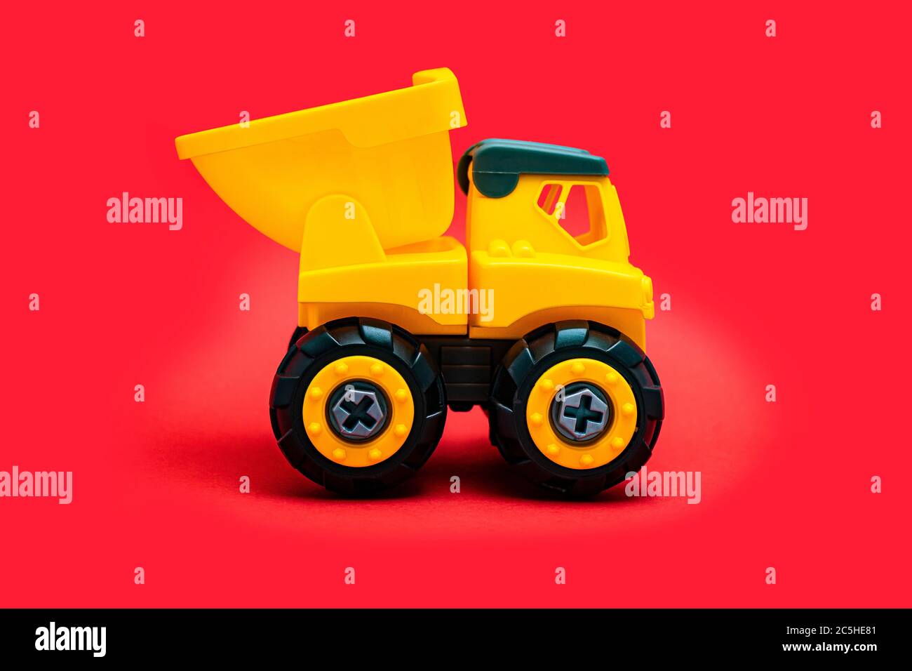 Yellow Toy Car Truck Over Red Background, studio shot, industrial cargo ...