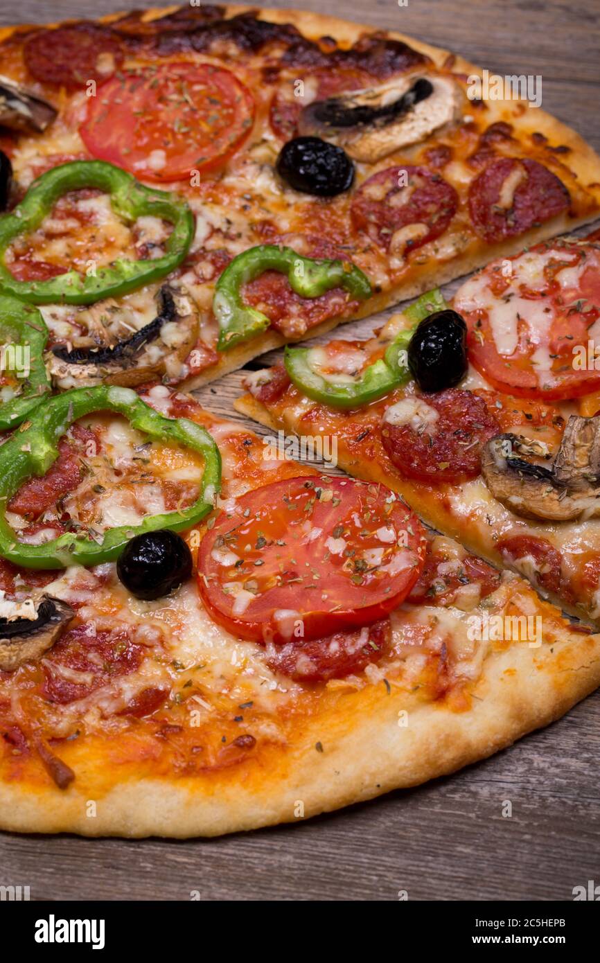 Pepperoni pizza with sliced vegetables on rustic wood background Stock ...