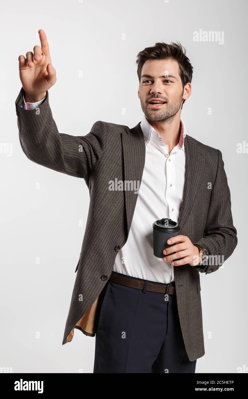 Image of young pleased businessman in jacket drinking coffee takeaway ...
