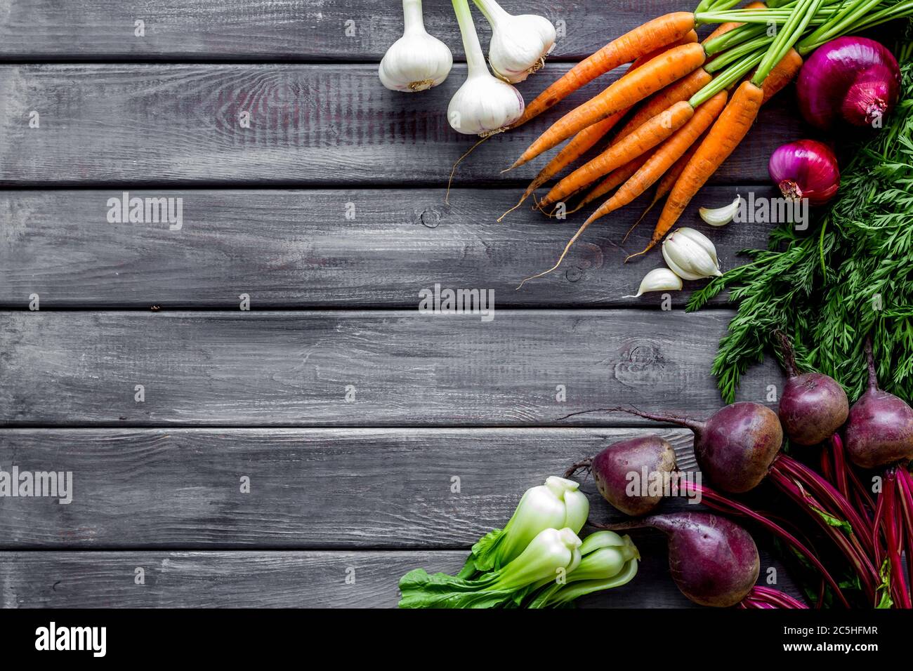 Flat lay of fresh vegetables and greenery on wooden table top-down copy ...