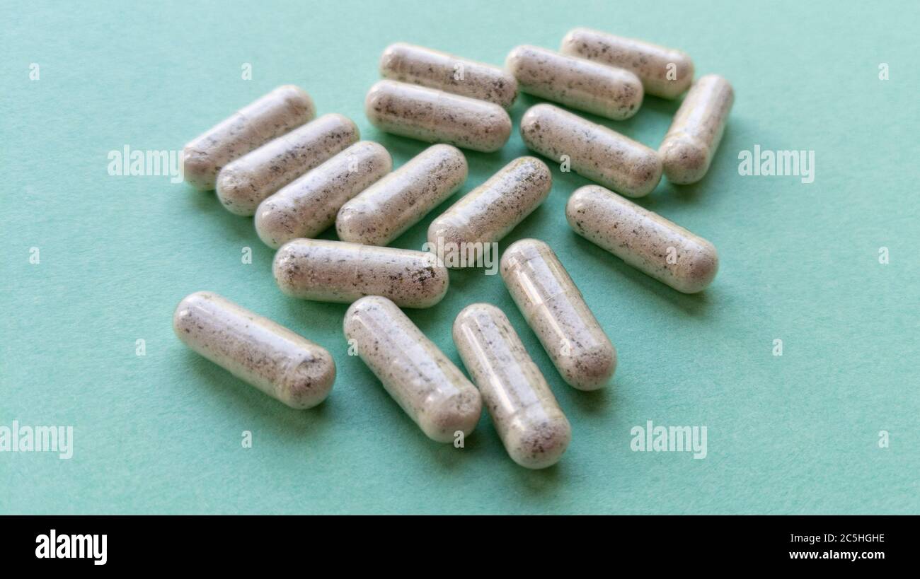 Pill capsules with dry kelp on mint background. Simple flat lay with ...
