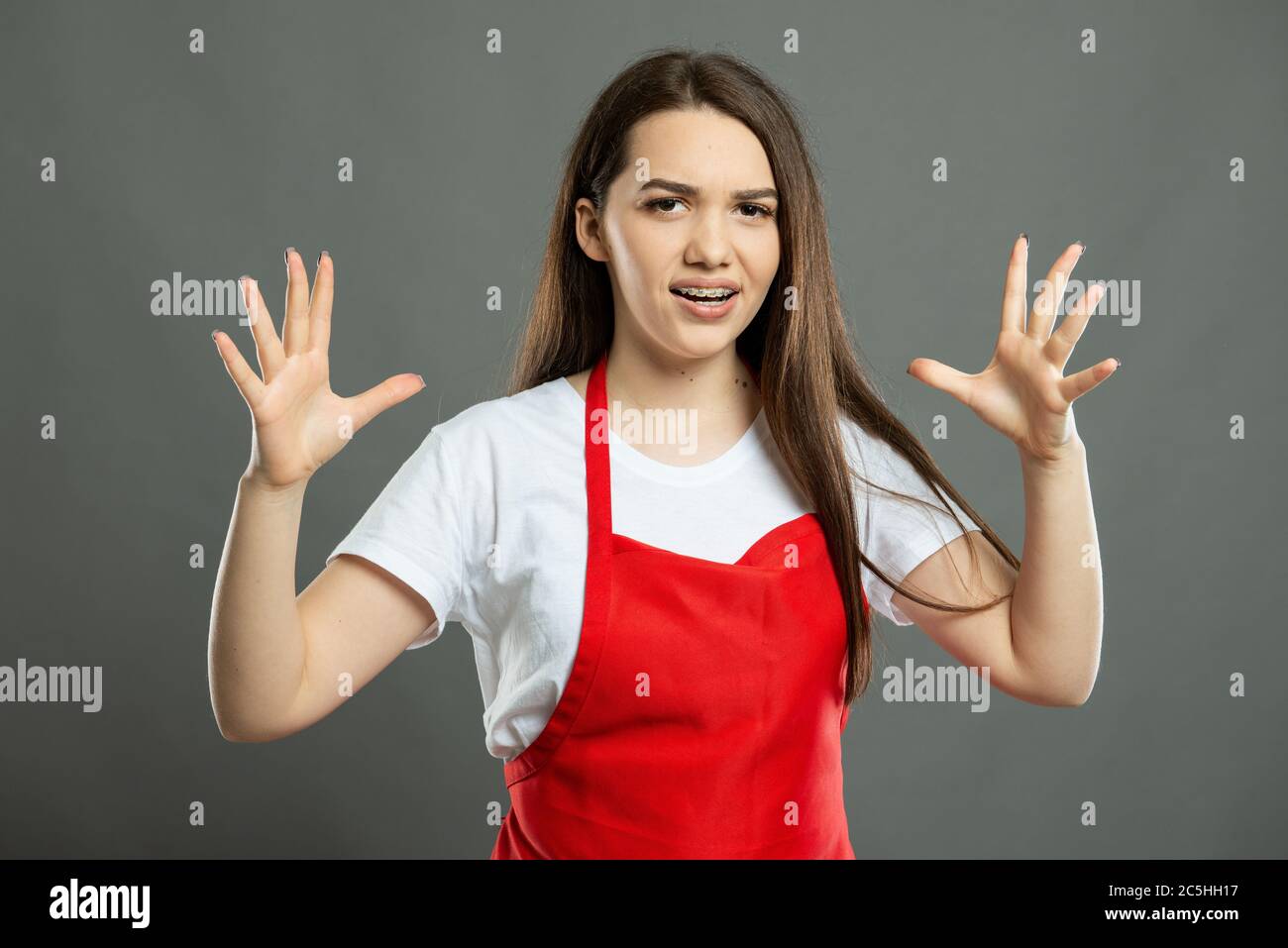 Portrait of young female supermarket employee yelling looking mad on ...
