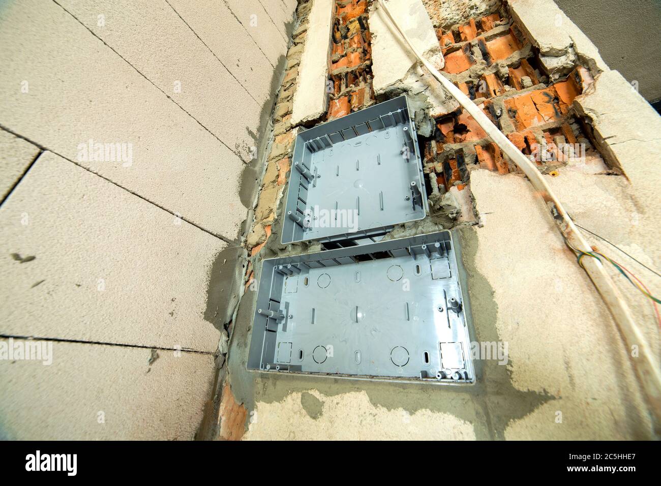 Electrical cables laid to plastic fusebox installed on the wall in a ...