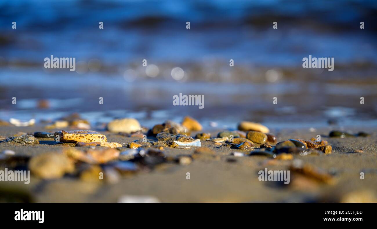 Waves at the seashore at sunset. Selective focus with shallow depth of ...