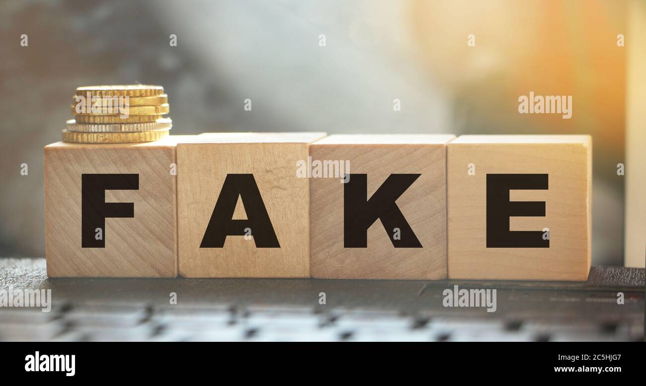 FAKE word written in wooden blocks on computer keyboard Stock Photo - Alamy