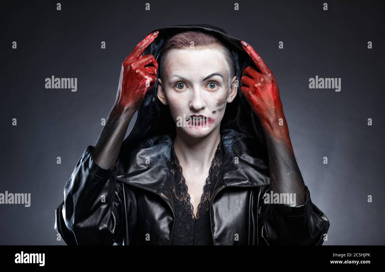 Picture of woman in black leather raincoat taking off hood Stock Photo ...