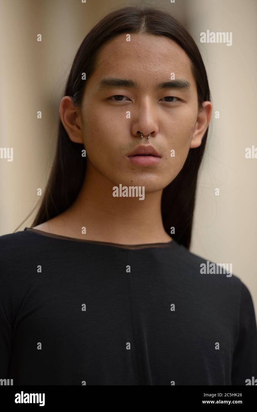 Face of young Asian man with long hair in the city Stock Photo - Alamy